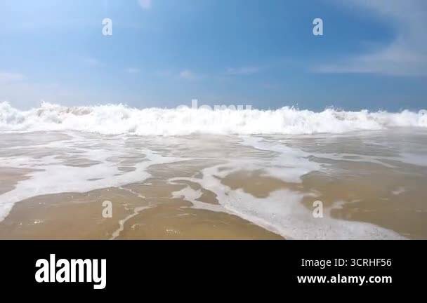 Ocean waves surge towards the sandy beach, creating a dynamic scene ...