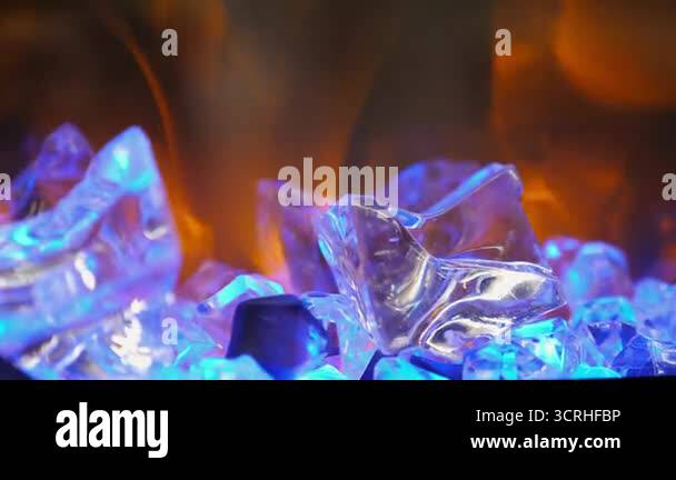 Glimmering ice cubes interact with vibrant blue and orange flames ...