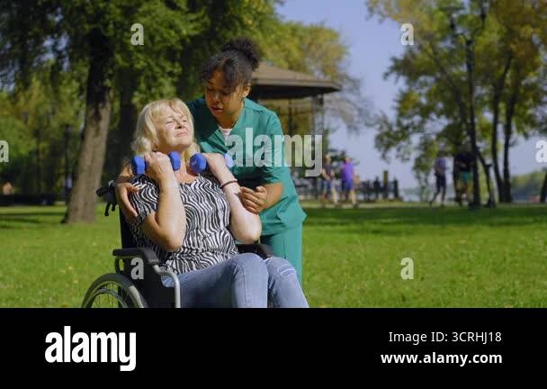 Determined elderly female wheelchair user with age-related mobility disability together with ...