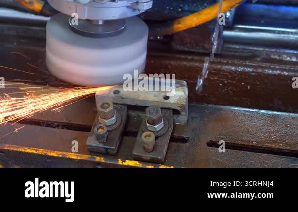 Industrial grinder creating sparks while polishing metal detail on ...