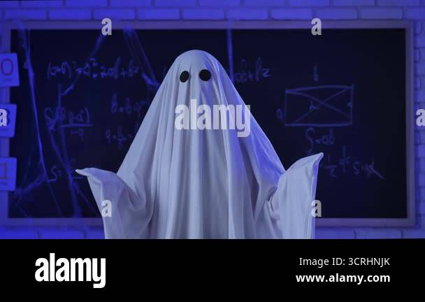 A person in a white ghost sheet sits near the blackboard and teaches a ...