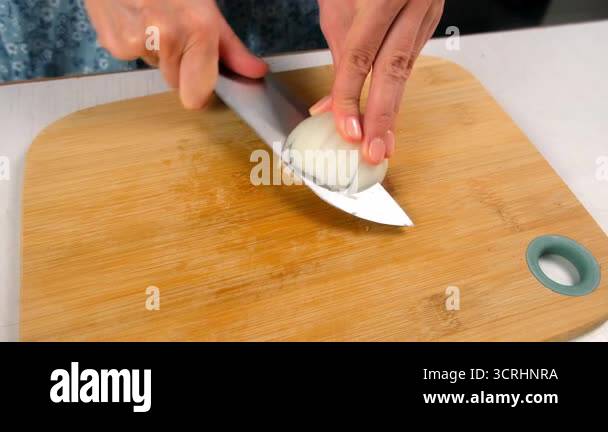Chef woman hands skillfully chopping white onion on cutting board on ...