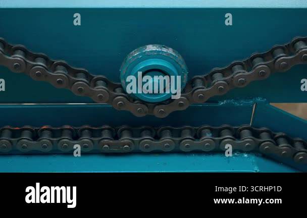 Close-up metal chain driving conveyor belt moving in industrial factory ...