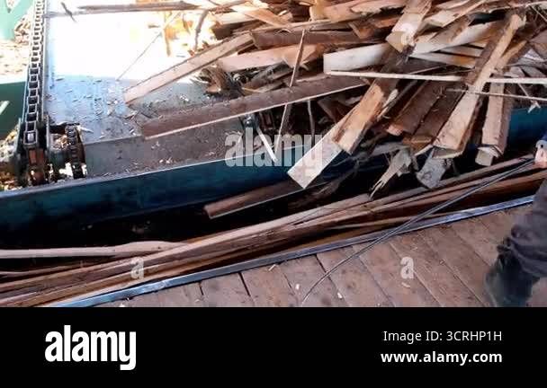 Wood scraps leftovers moving on conveyor belt to chopping machine at ...