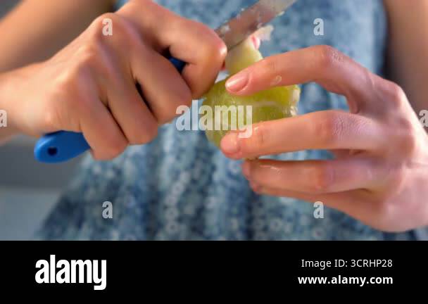 Woman hands peeling lime fruit using knife cooking on kitchen at home ...