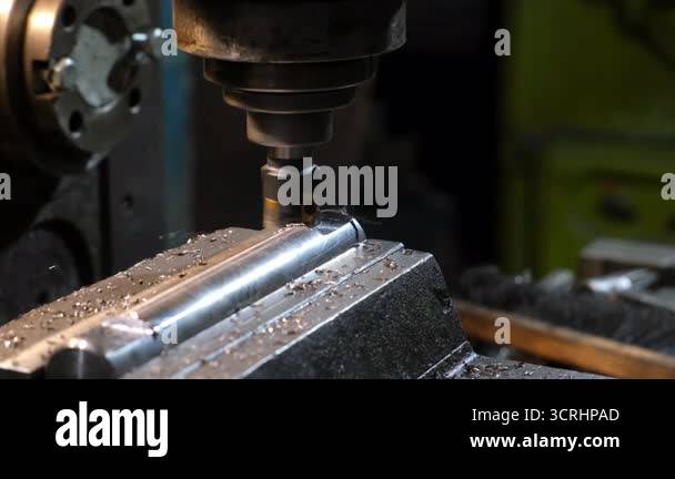 Milling machine removing material from metal rod on industrial factory ...