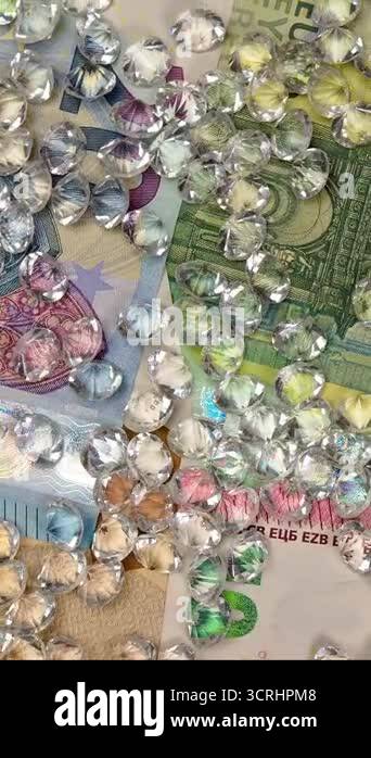 Beautiful gems of various colors lie scattered among banknotes ...