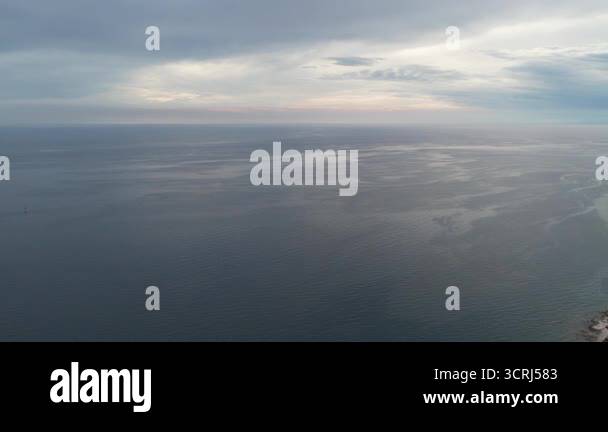 Tranquil seascape with calm waves and cloudy sky over the open horizon ...