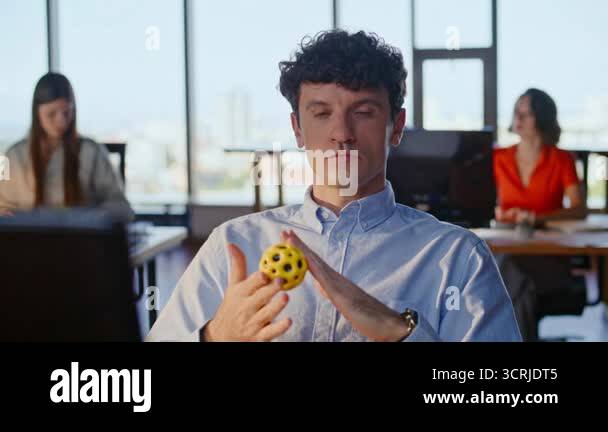 Closeup thoughtful man pondering tasks holding ball in corporate office ...