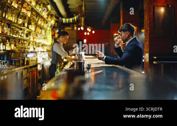 Lonely man resting bar sitting counter with cocktail. Formal suit guy ...