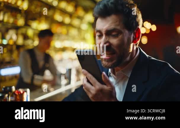 Nervous man arguing mobile phone call at night pub closeup. Angry ...