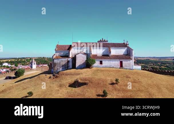 Drone view ancient Portugal monastery raising over sunlit settlement ...