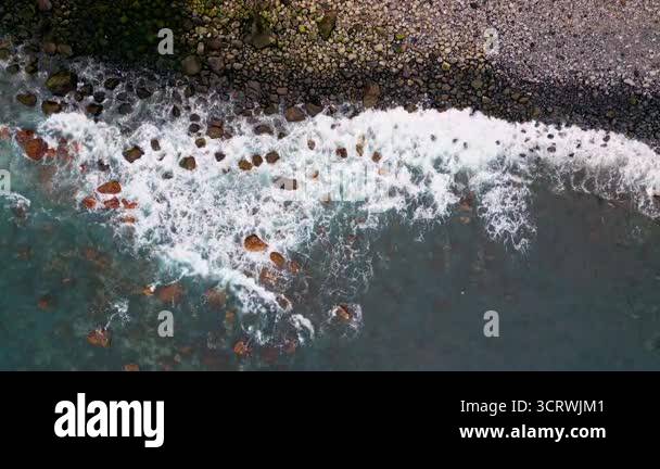 Top shot sea water foaming on stony shoreline. Picturesque ocean ...