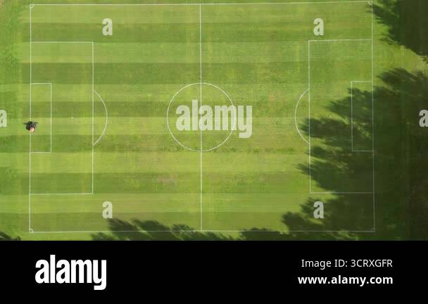 4K hyperlapse of a groundsman mowing the grass on a football pitch in ...