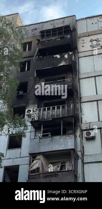A damaged residential building with burnt-out balconies after shelling ...