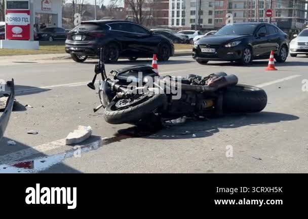 A wrecked motorcycle (bike) lies on its side on the asphalt after a ...