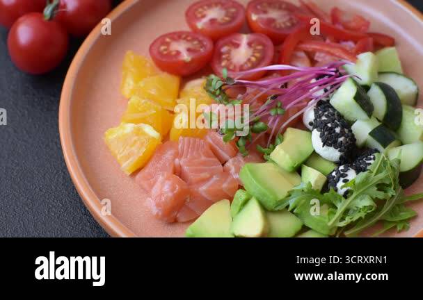 Bowl with salmon pieces, cheese, tomatoes, peppers and avocado. Salmon ...