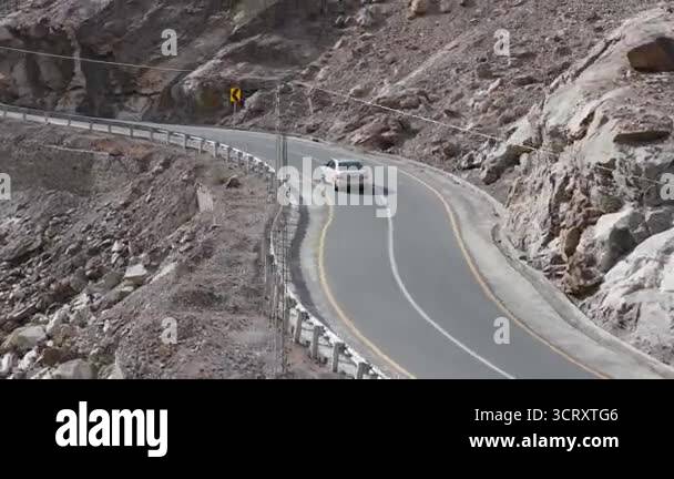 Aerial view of a car navigating a winding mountain road in Pakistan ...