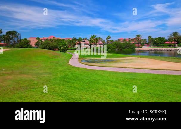 Beautiful view of golf course with green lawn, sand, palm trees and ...