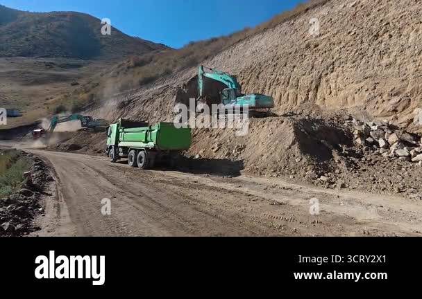 BISHKEK, KYRGYZSTAN - AUGUST 30, 2025: Excavator loads soil into a dump ...