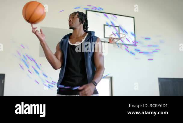 Male athlete spinning basketball on finger, tucking arm as graphics ...