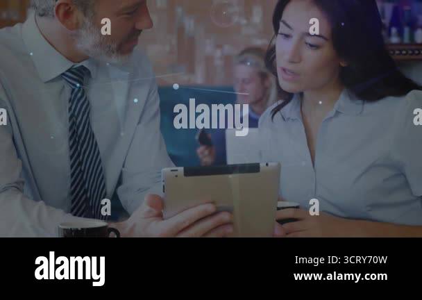 Senior consultant tapping tablet and generating digital chart while project lead confirming ...