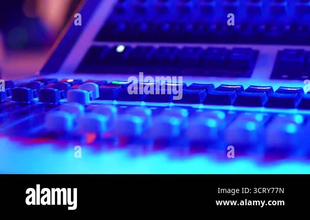 DJ sound mixer board illuminated with neon lights in a nightclub ...