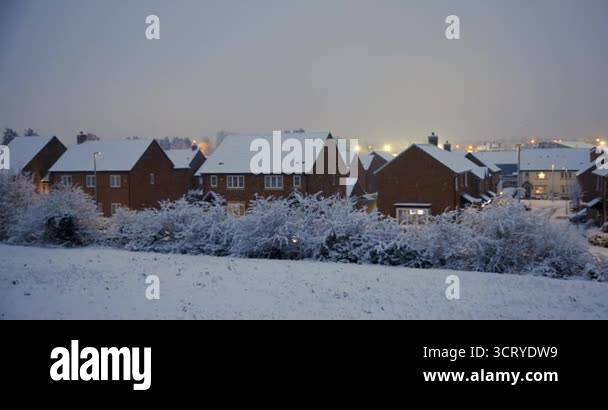 Cinematic shot of snow falling at night on a cold winter day in England ...