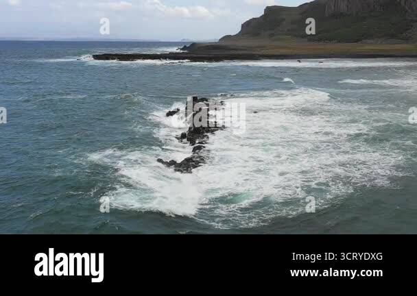 Aerial slow motion view of waves and rock coastline in Scotland ...