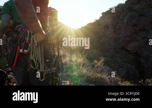 Cropped unrecognizable men ready for traditional climbing. He's ...