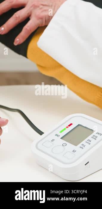 Close-up of a person accurately measuring their blood pressure at home ...
