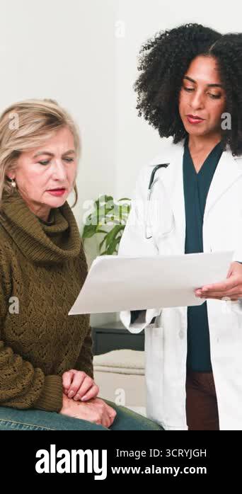 A compassionate female doctor discusses health information with her ...