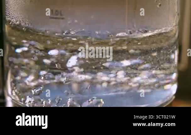 Closeup shot of boiling water inside a glass kettle recorded in real ...