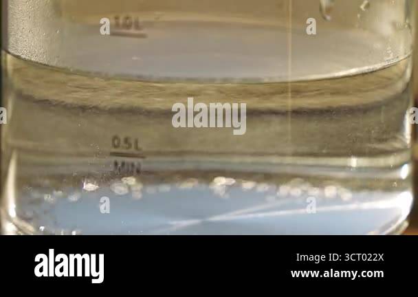 Timelapse of boiling water inside a glass kettle under natural sunlight ...