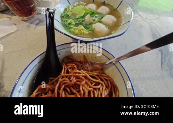 a bowl of dried wonton kicap noodles with fuzhou fish ball soup Stock ...