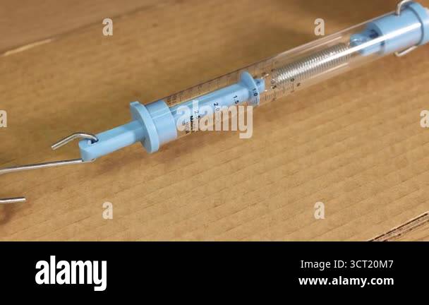 A spring scale measures friction on cardboard, showing gradual movement ...