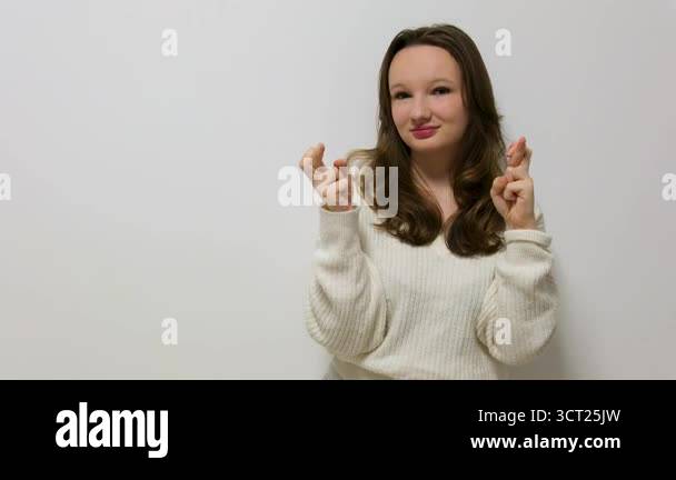 Hope, face and woman with fingers crossed in studio for feedback ...