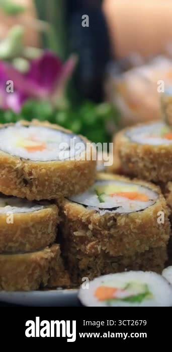 Fried sushi rolls hand holding deep-fried sushi roll with rice ...