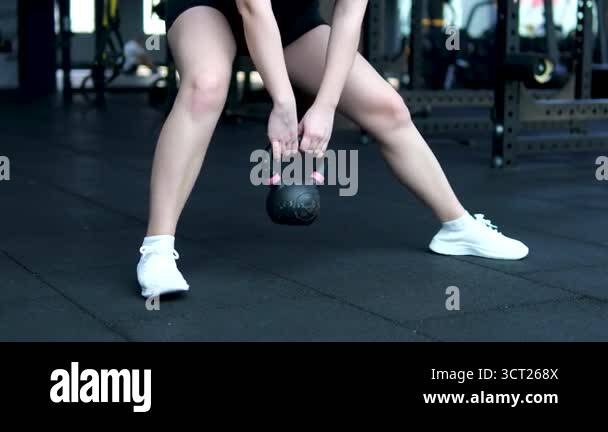 Sequences of vertical shots of a strong woman exercising squatting with ...