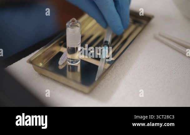 A close-up of medical supplies: a vial and syringe prepared for a ...