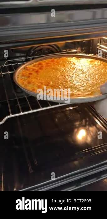 Anonymous person turn pan with chickpea flour flatbread in oven ...