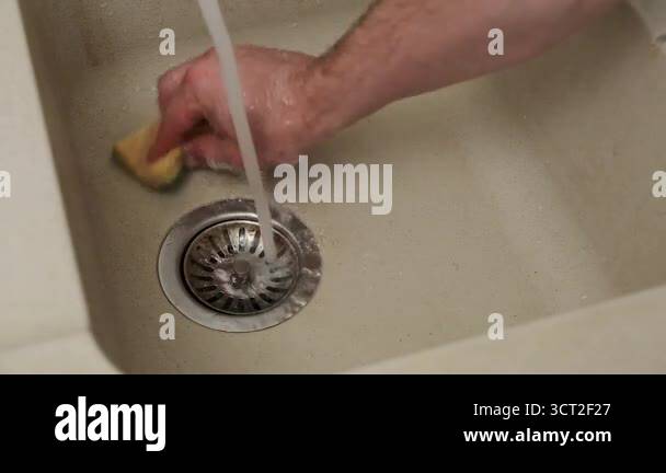 Efficient kitchen cleaning with running water and sponge in action ...