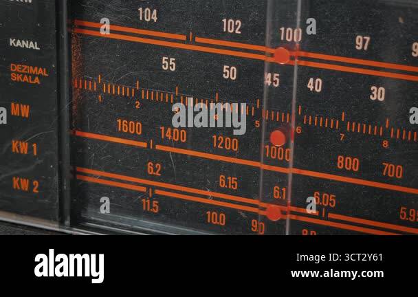 Close-up of a vintage radio tuner dial with orange numbers, showing a ...