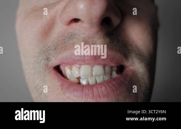 Extreme macro shot of lower part of mans face, showing lips pulling ...