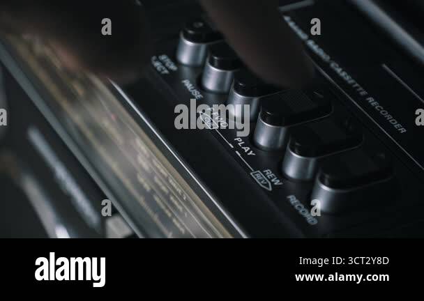 Close-up angled shot of finger pressing PLAY button on vintage cassette ...