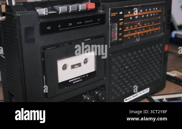 Close-up of finger pressing play and stop buttons on black retro tape ...