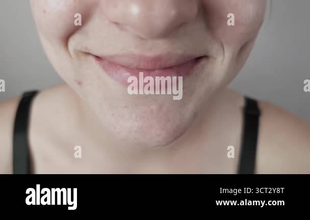 Macro front view of female face with a gentle, closed-mouth smile ...