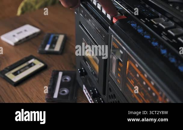 Close-up of hand pressing eject button on vintage boombox, removing old ...
