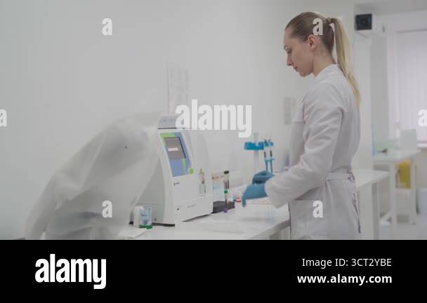 Female laboratory technician using hematology blood analyzer. Medical ...