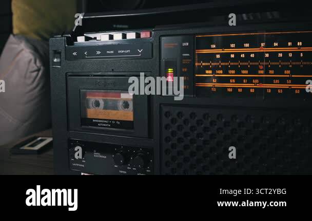 Close-up shot of a vintage cassette tape playing in a black retro ...